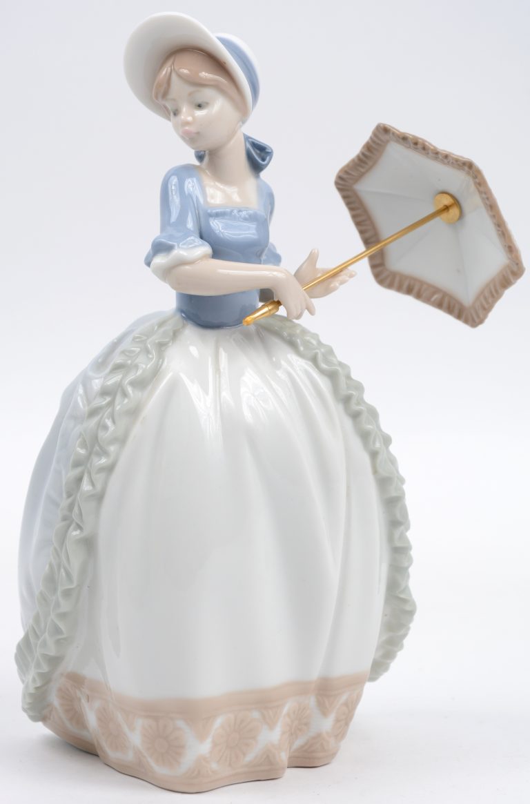 “Dame met parasol”. Een beeldje van meerkleurig porselein. Onderaan gemerkt en gedateerd 1985 ...